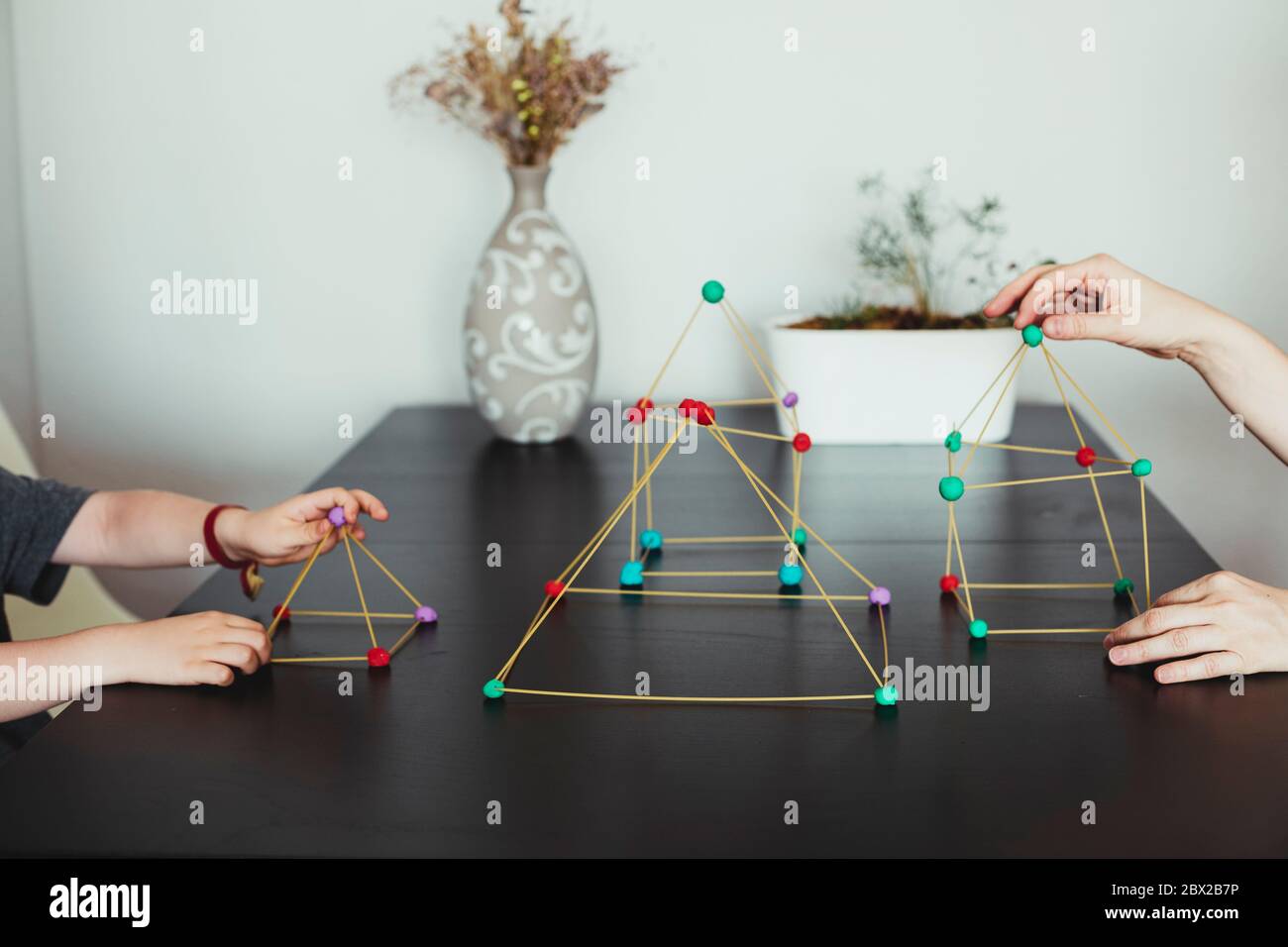 Mother and son making geometric shapes from sticks and play dough Stock ...