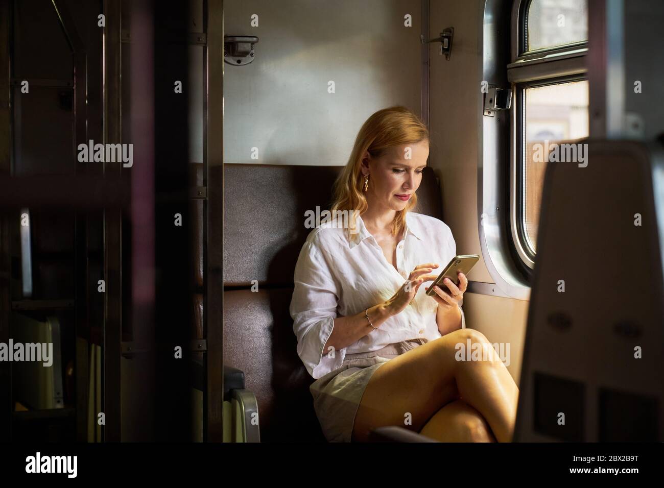 Mature woman smart phone train station hi-res stock photography and ...