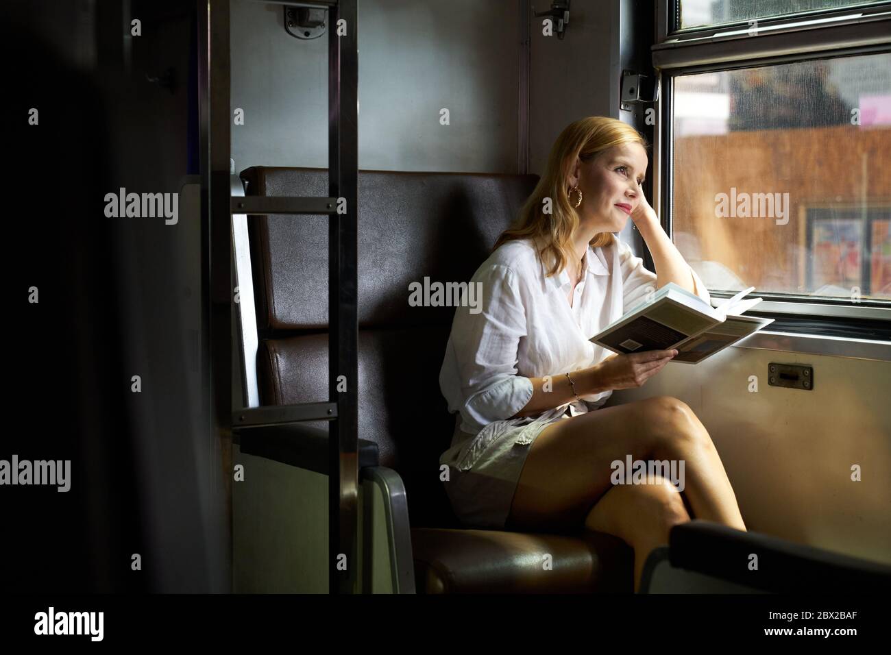 Businesswoman reading book train hi-res stock photography and images ...