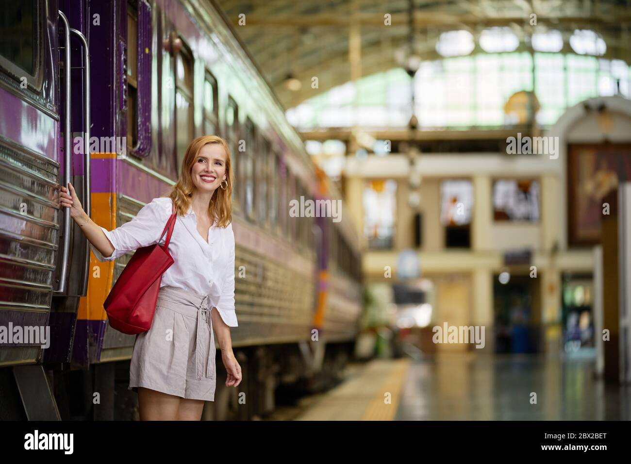 A woman getting off a train Stock Photo - Alamy