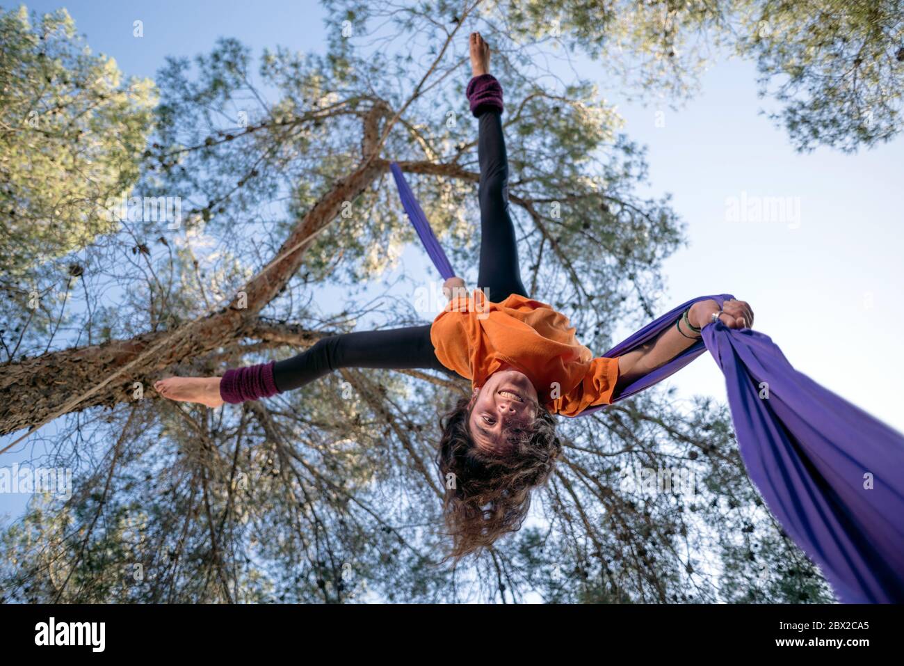 Young girl acrobat. Practicing aerial silks. Strong woman doing circus ...