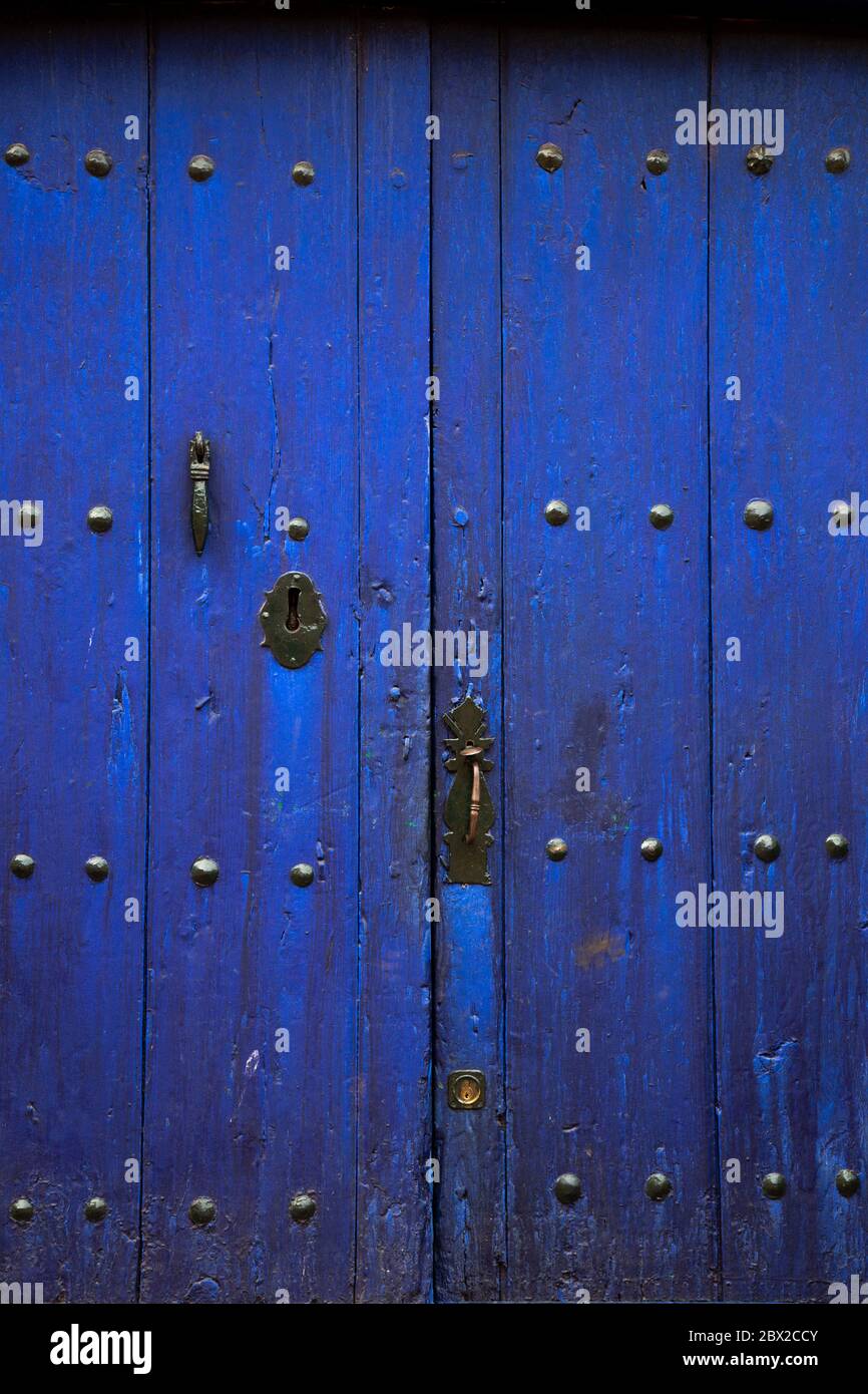 Old rustic wooden door with different layers of cracked dark blue paint ...