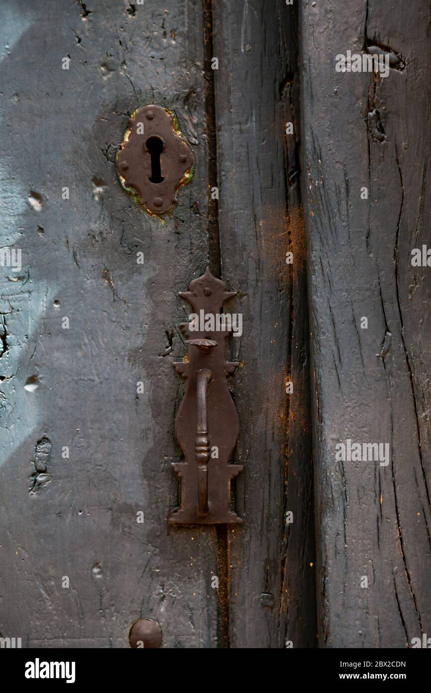 Detail of a rusty handle and lock of an old rustic wooden door with ...