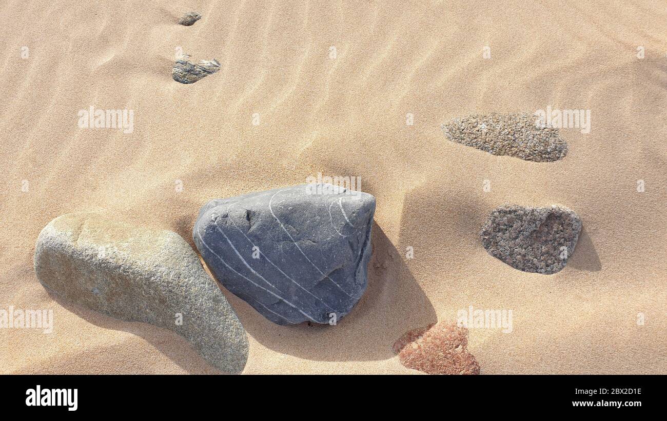 Rocks in sand Stock Photo - Alamy