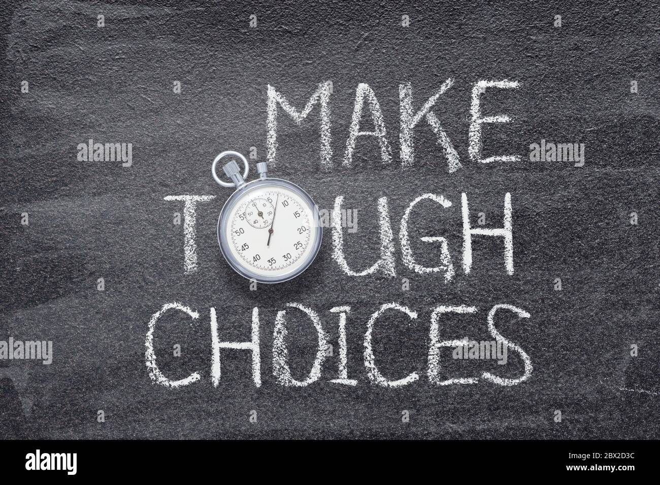 make tough choices written on chalkboard with vintage precise stopwatch ...