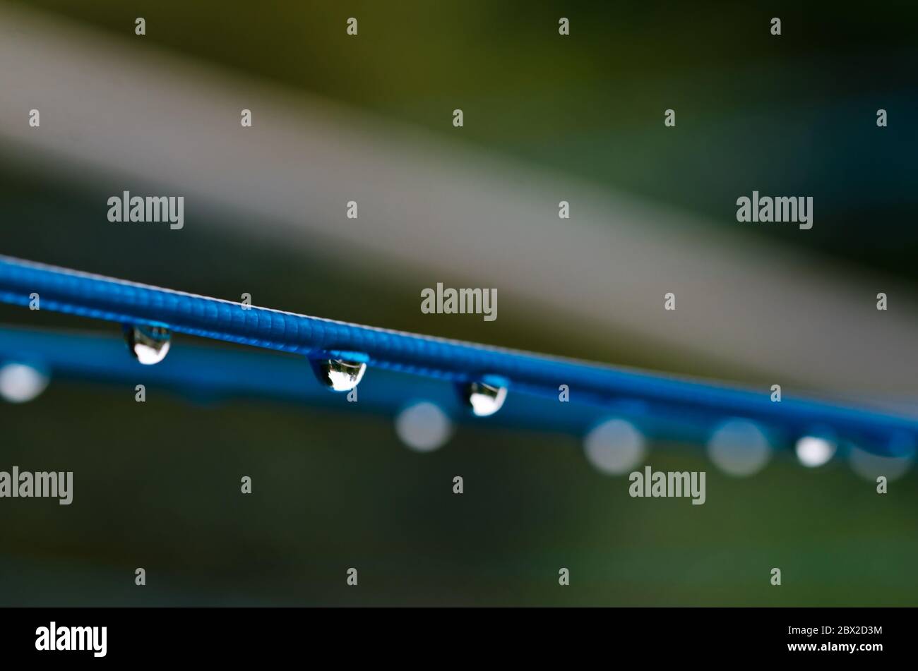 Blue clothing lines of a clothes spin with many raindrops at the string ...