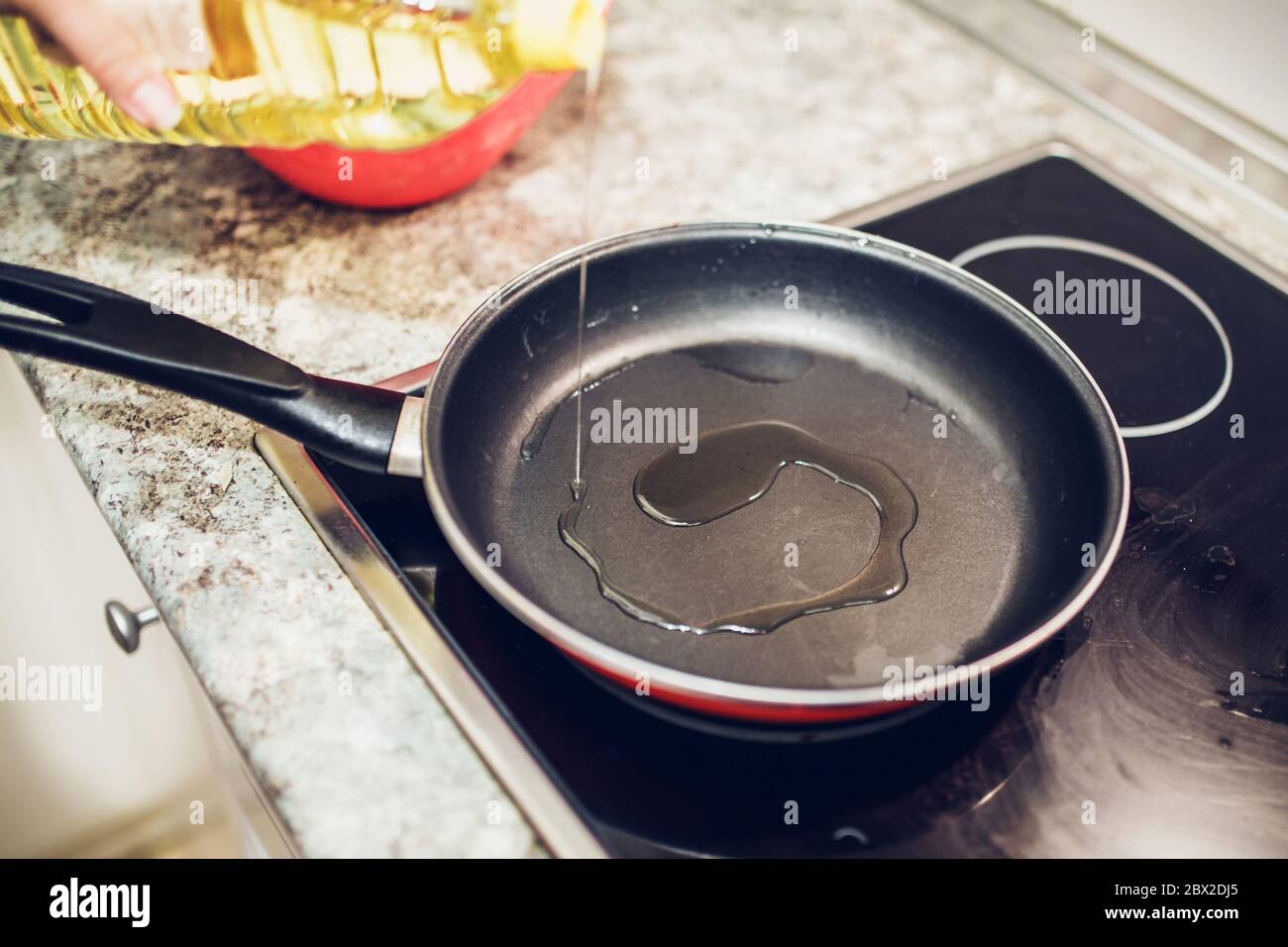 thin stream of sunflower oil in a hot frying pan Stock Photo - Alamy