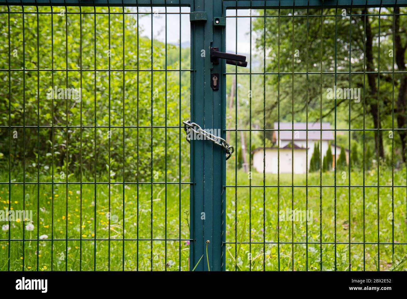 Fence from the house. Guarding the property. In the background greenery ...