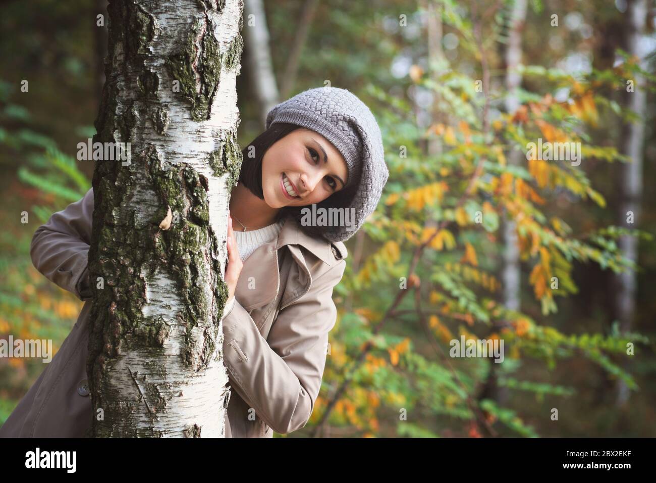 Beautiful smile from young woman among birch trees. Seasonal and ...