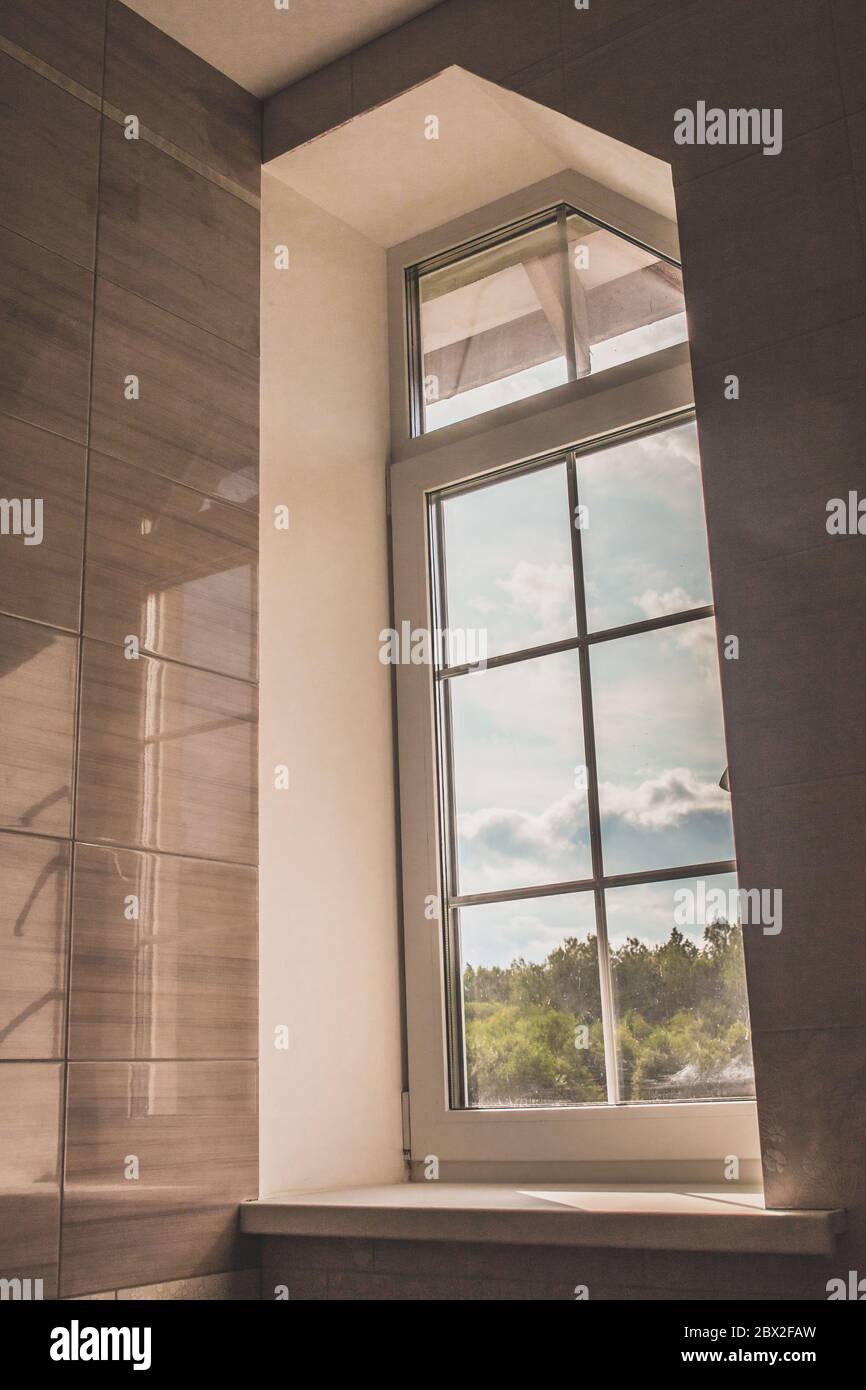 Soft warm light through a narrow high window inside the house - a ...