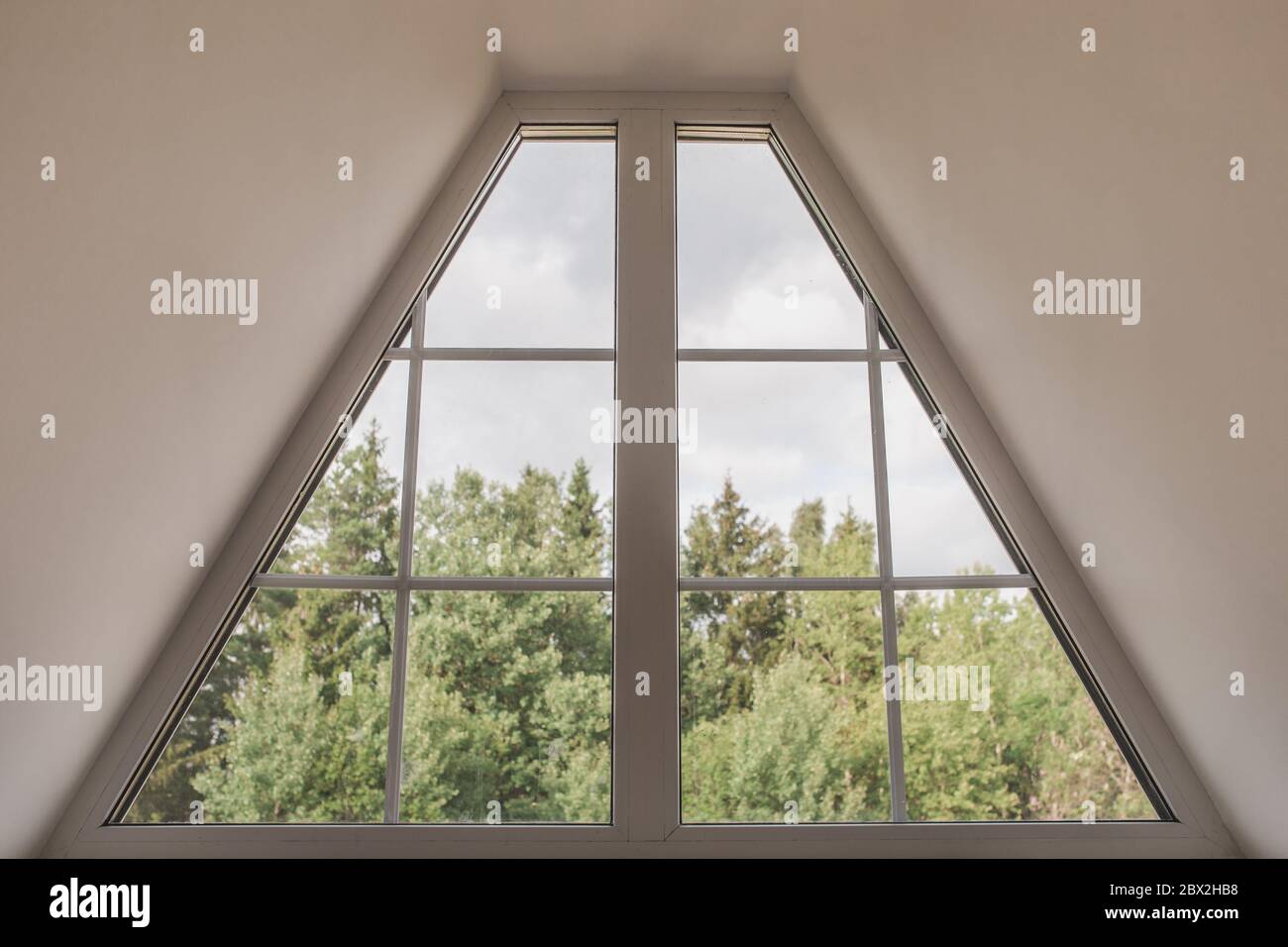 View of the green trees and the forest from the window in the attic ...