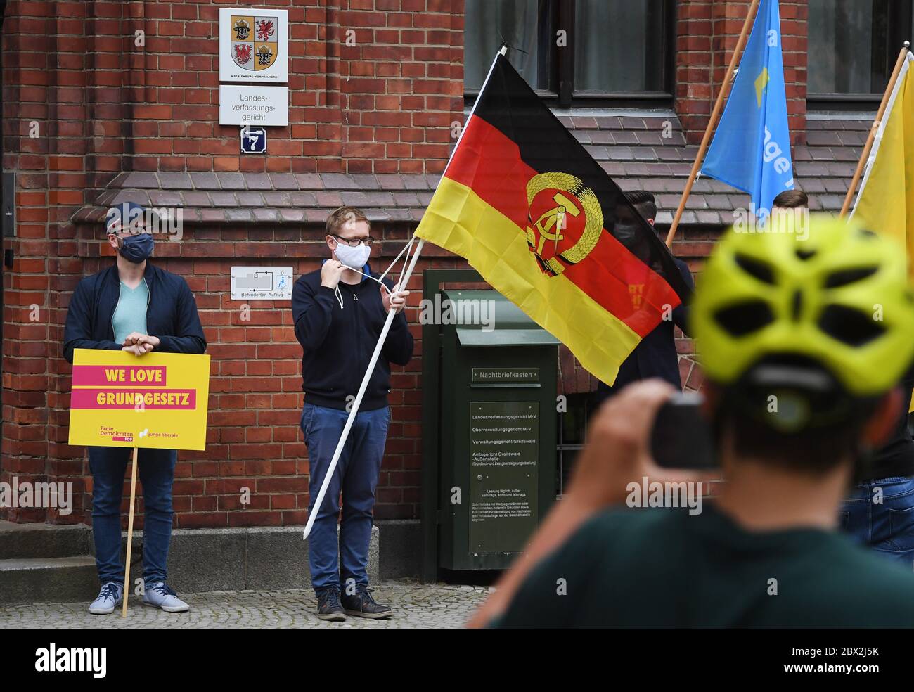 Greifswald, Germany. 04th June, 2020. A member of the FDP carries a GDR ...