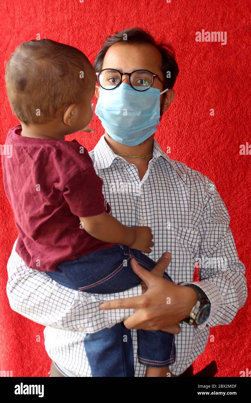 father wearing surgical mask on face and carry his baby son playing ...