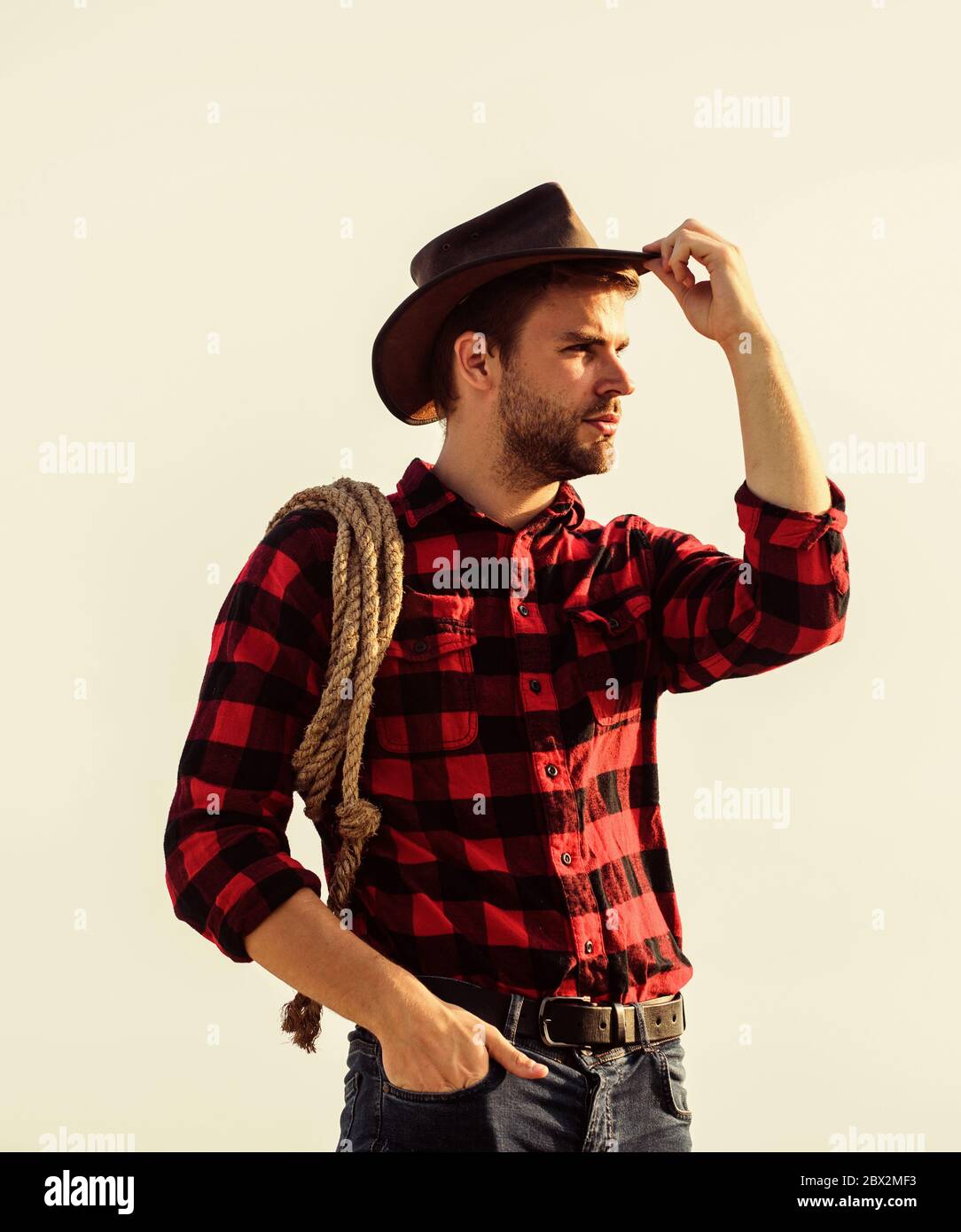 Ranch worker. Life at ranch. Cowboy with lasso rope sky background. Eco ...