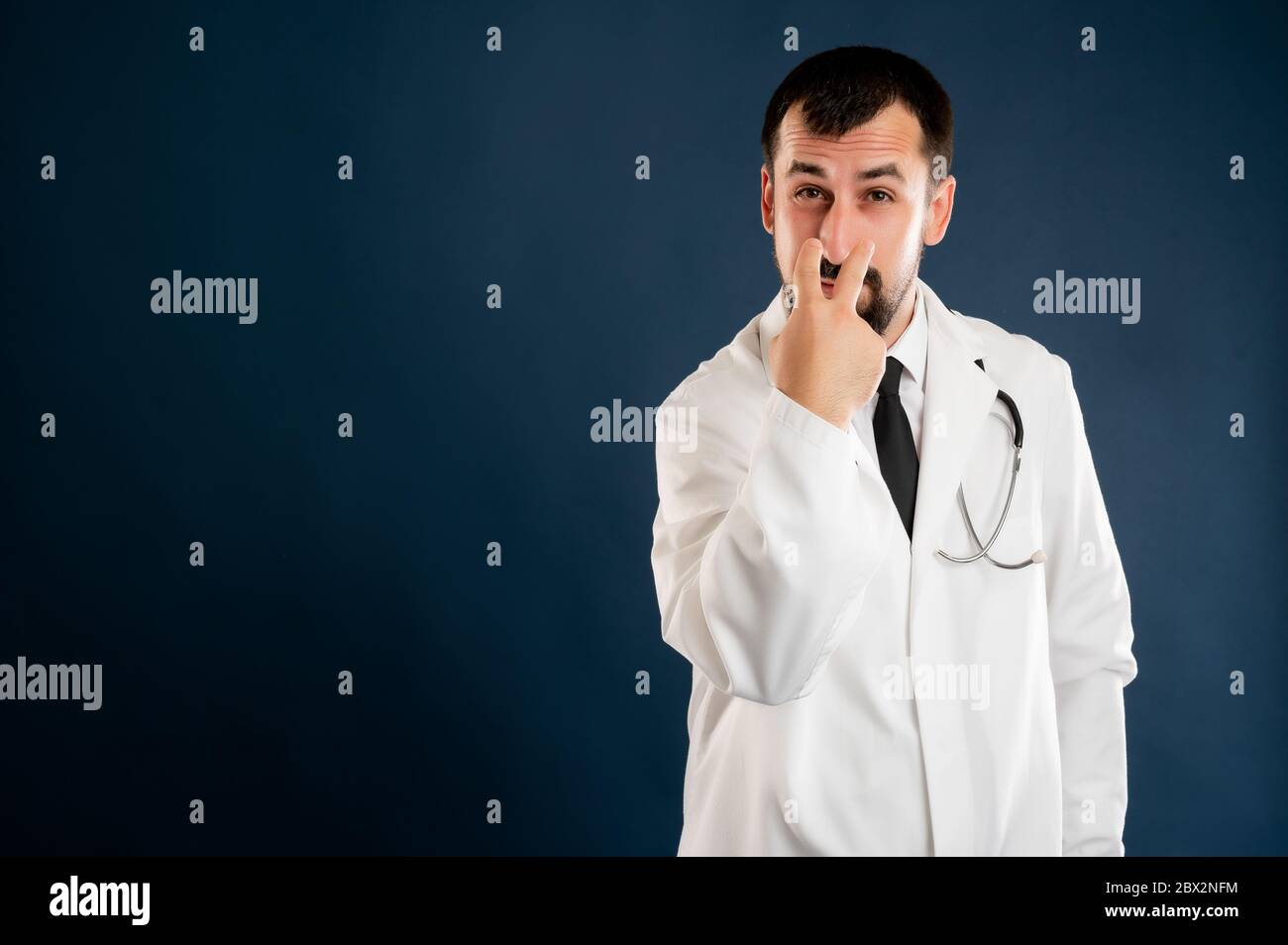 Portrait of male doctor with stethoscope in medical uniform doing look ...
