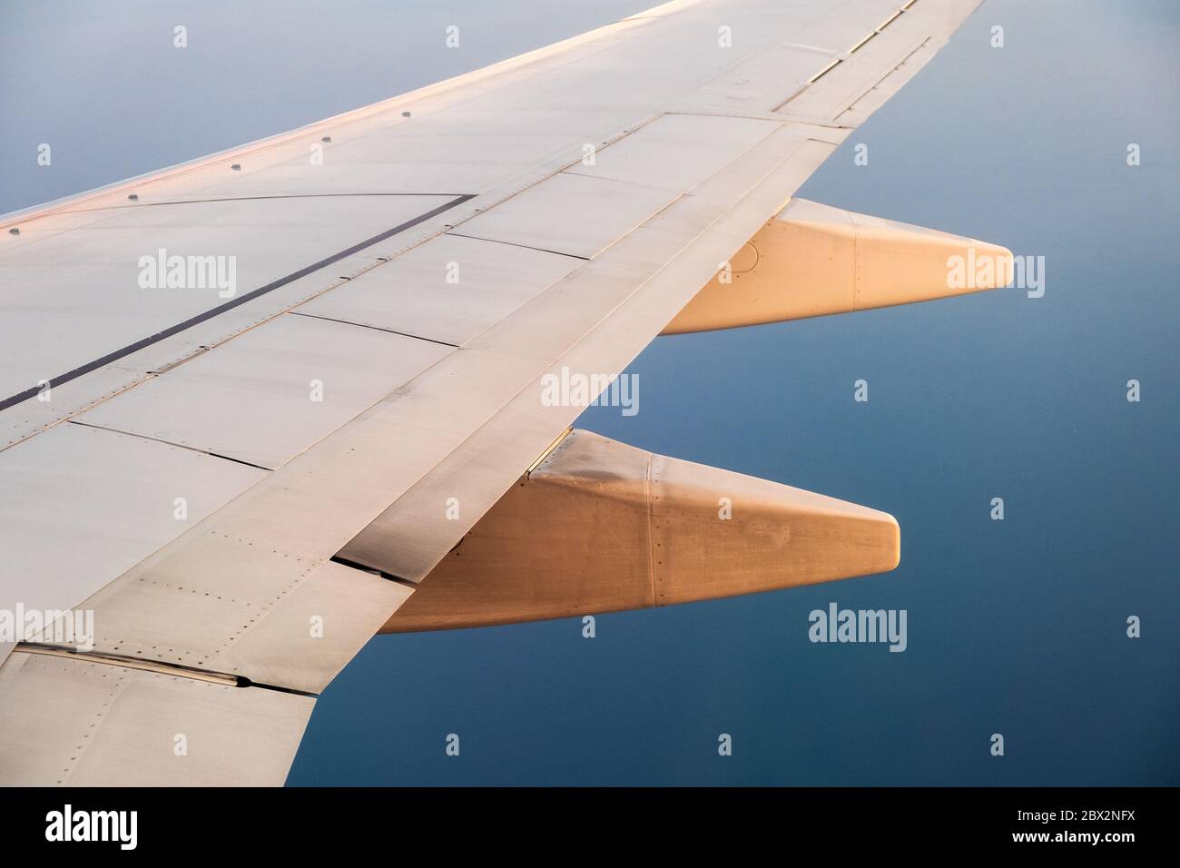 View from airplane on the aircraft white wing flying over ocean ...