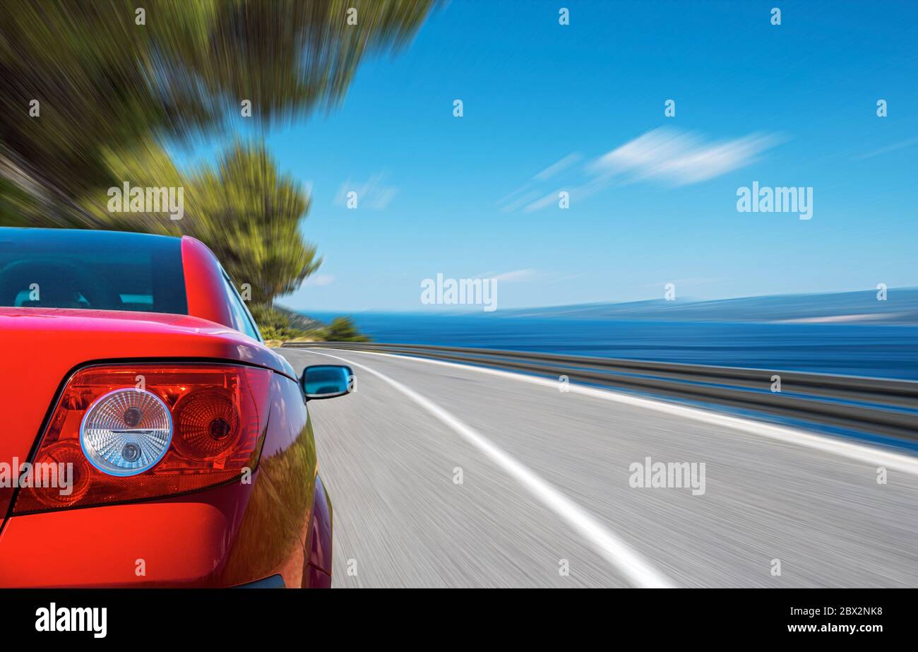 Red car is driving on the road Stock Photo - Alamy