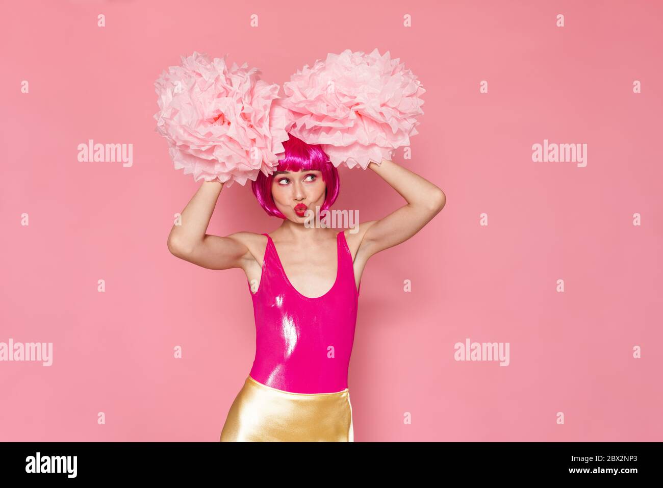 Image of amusing woman in wig making kiss lips and dancing with pom ...
