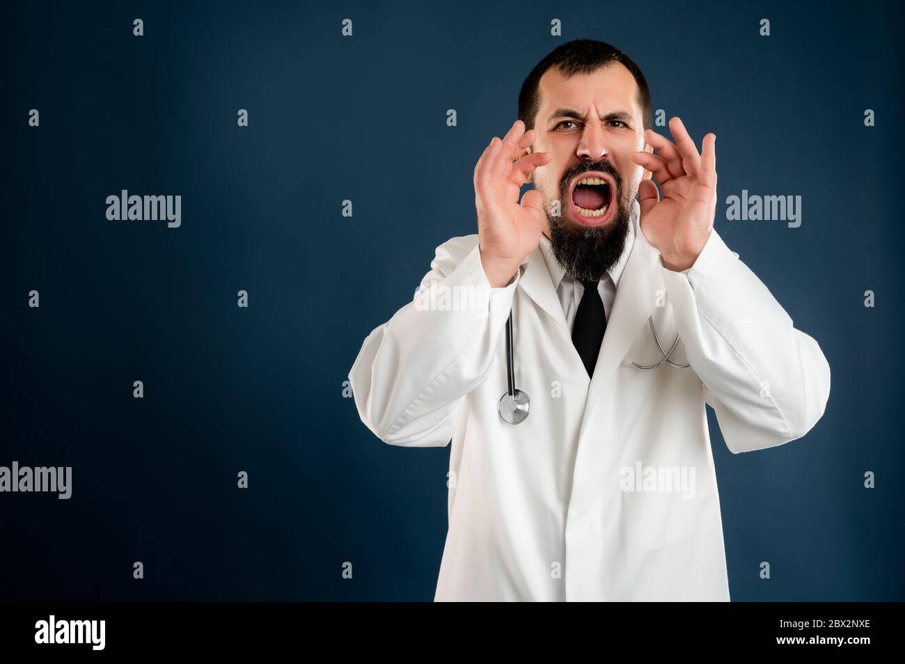 Portrait of male doctor with stethoscope in medical uniform shouting ...