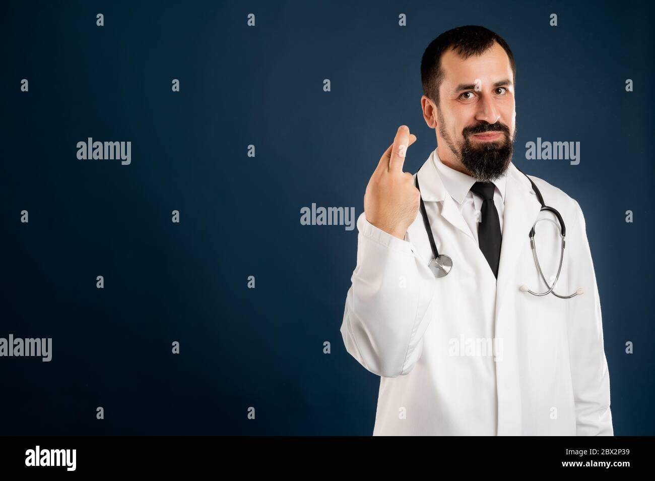 Portrait of male doctor with stethoscope in medical uniform showing ...
