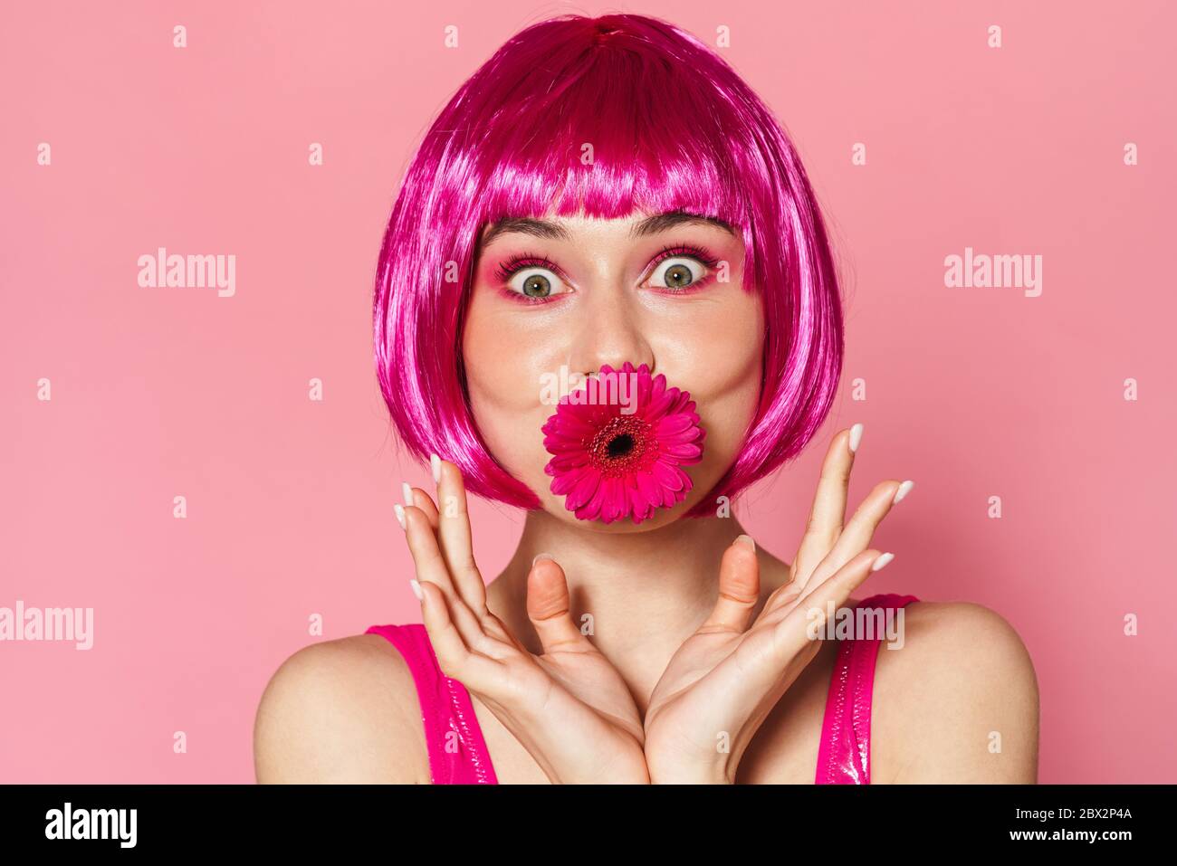 Image of amusing beautiful woman in wig posing with flower in her mouth ...