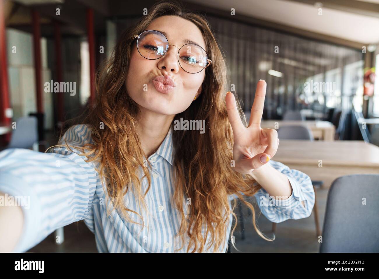 Beautiful woman gesturing peace sign hi-res stock photography and images - Alamy