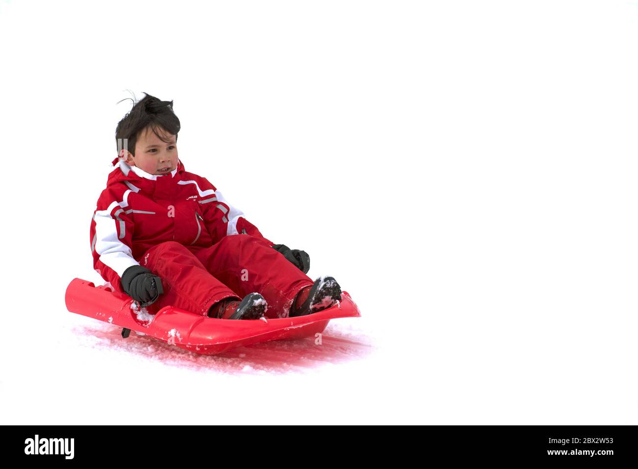 Boy on a sledge in winter Stock Photo - Alamy