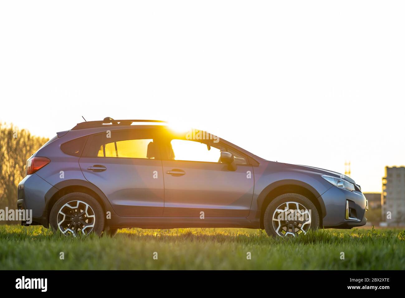 Landscape with blue off road car on green grass at sunset. Traveling by ...