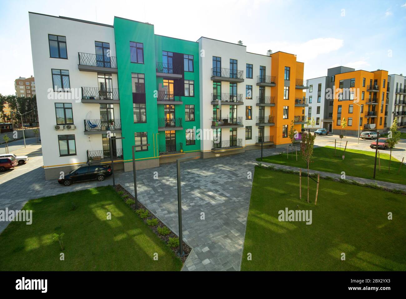 Yard between residential apartment buildings with green grass lawns and ...