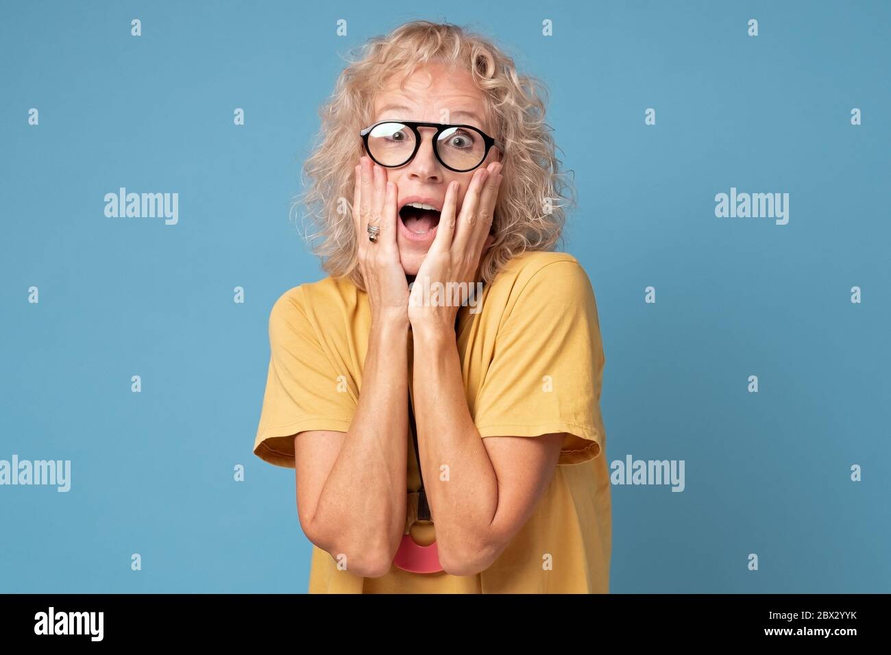 Mature woman holding head in hands feels unhealthy Stock Photo - Alamy