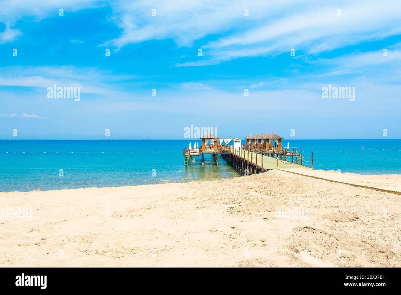 Wooden beach pavilions on the shore of a sandy beach - the ...