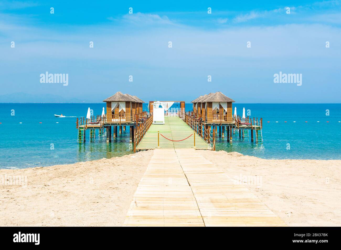 Wooden beach pavilions on the shore of a sandy beach - the ...