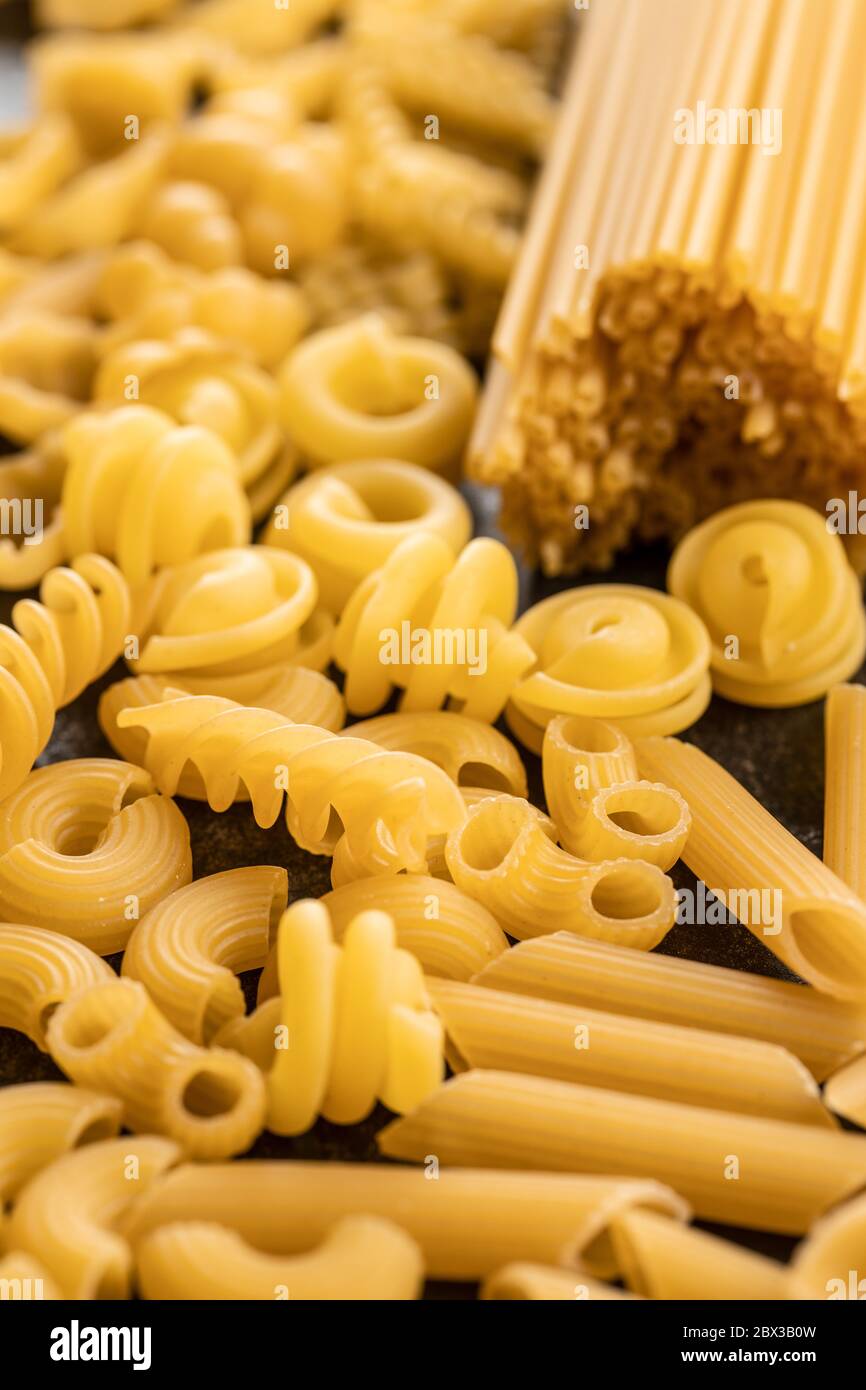 Various types of raw italian pasta on kitchen table Stock Photo - Alamy