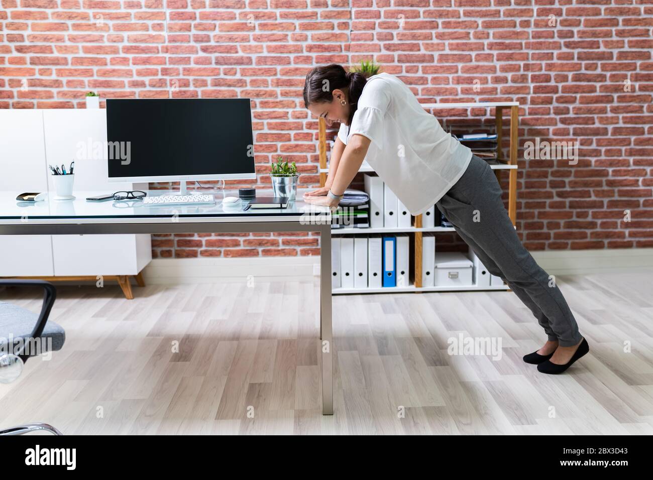 Side View Of A Young Businesswoman Doing Push Up On Office Desk Stock ...