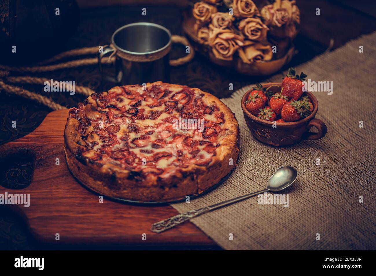 Wodden cake board with homemade strawberry cake on dark stone table and ...