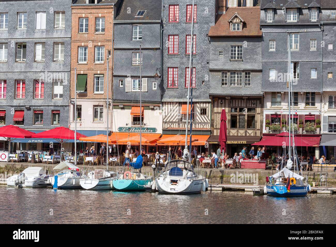Harbor of historic city Honfleur with sailing ships and restaurants ...