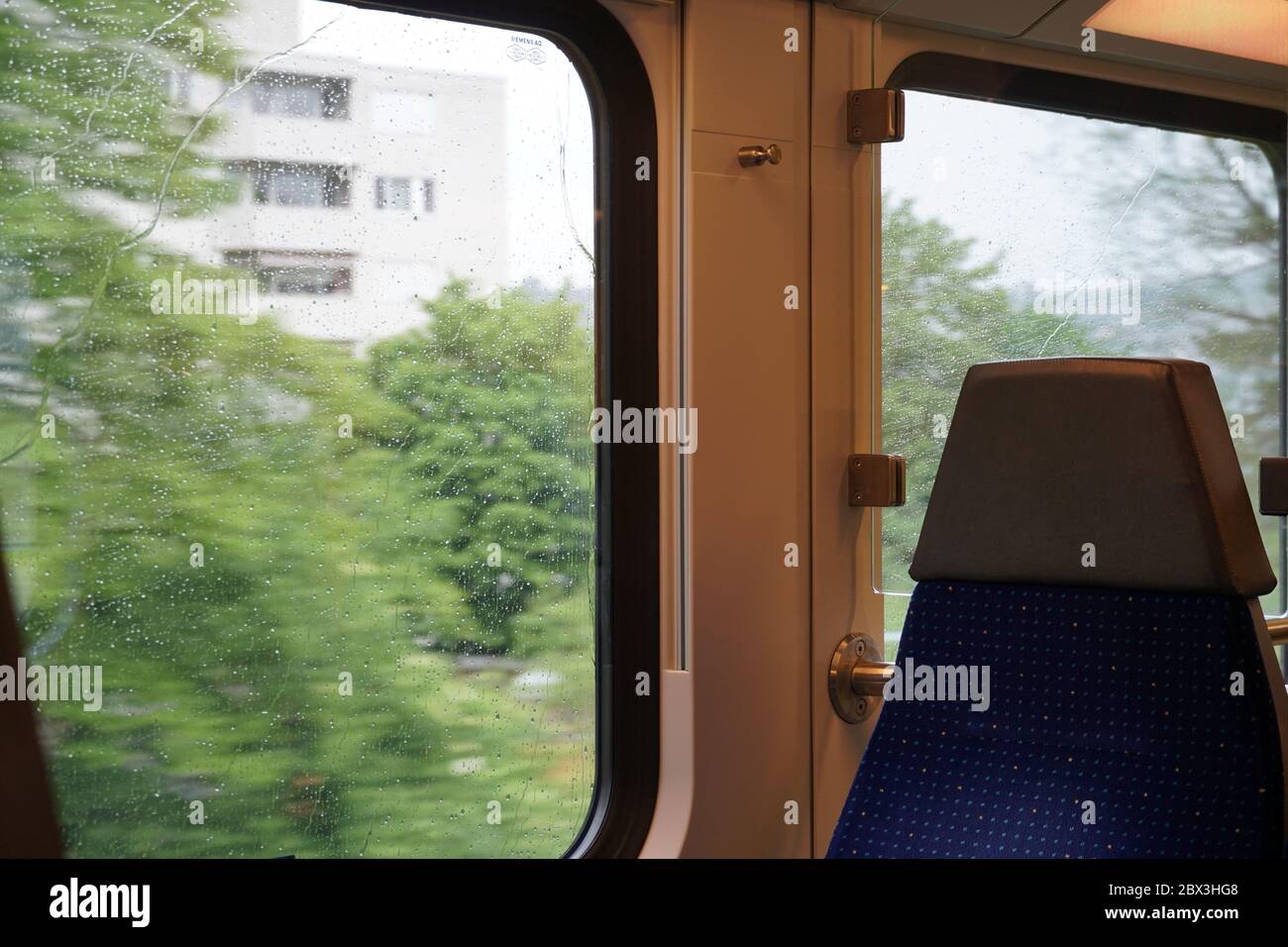 Empty commuter train on a rainy day, the windows are covered by ...