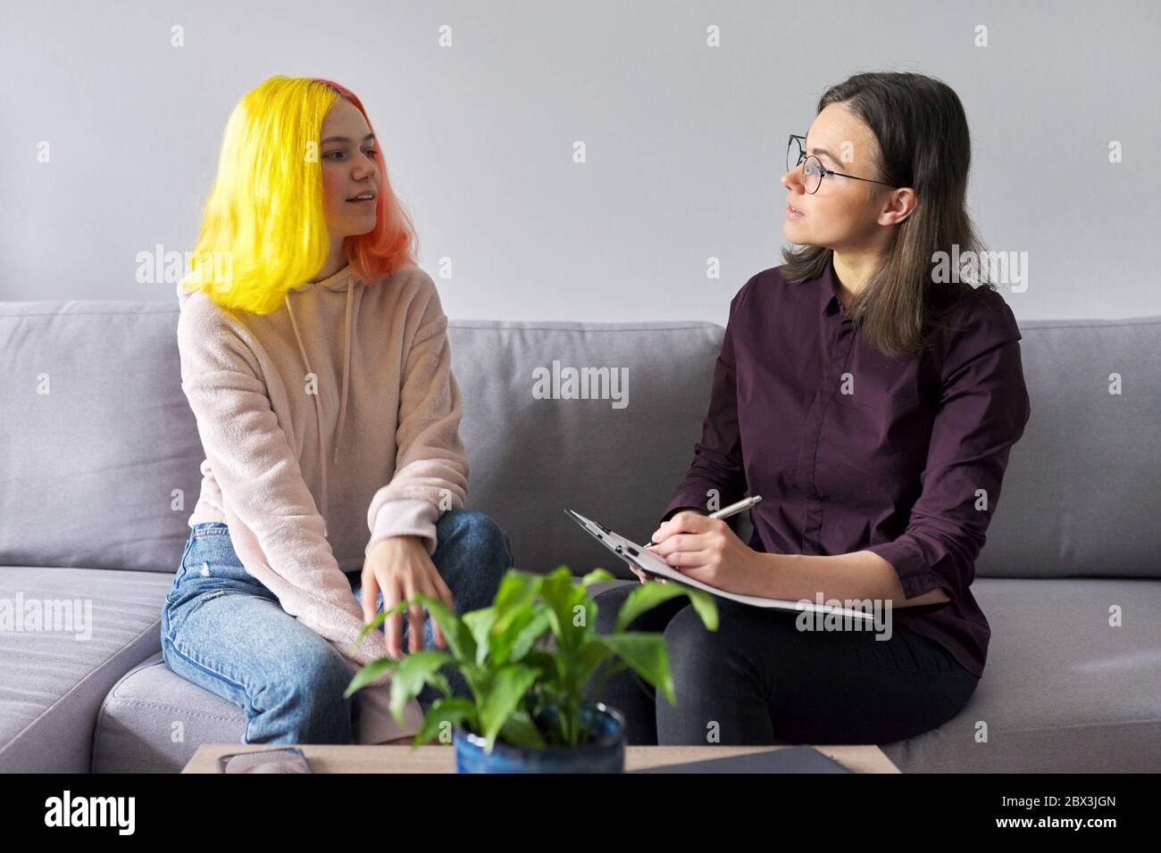 Teen girl giving interview to social worker. School psychologist ...