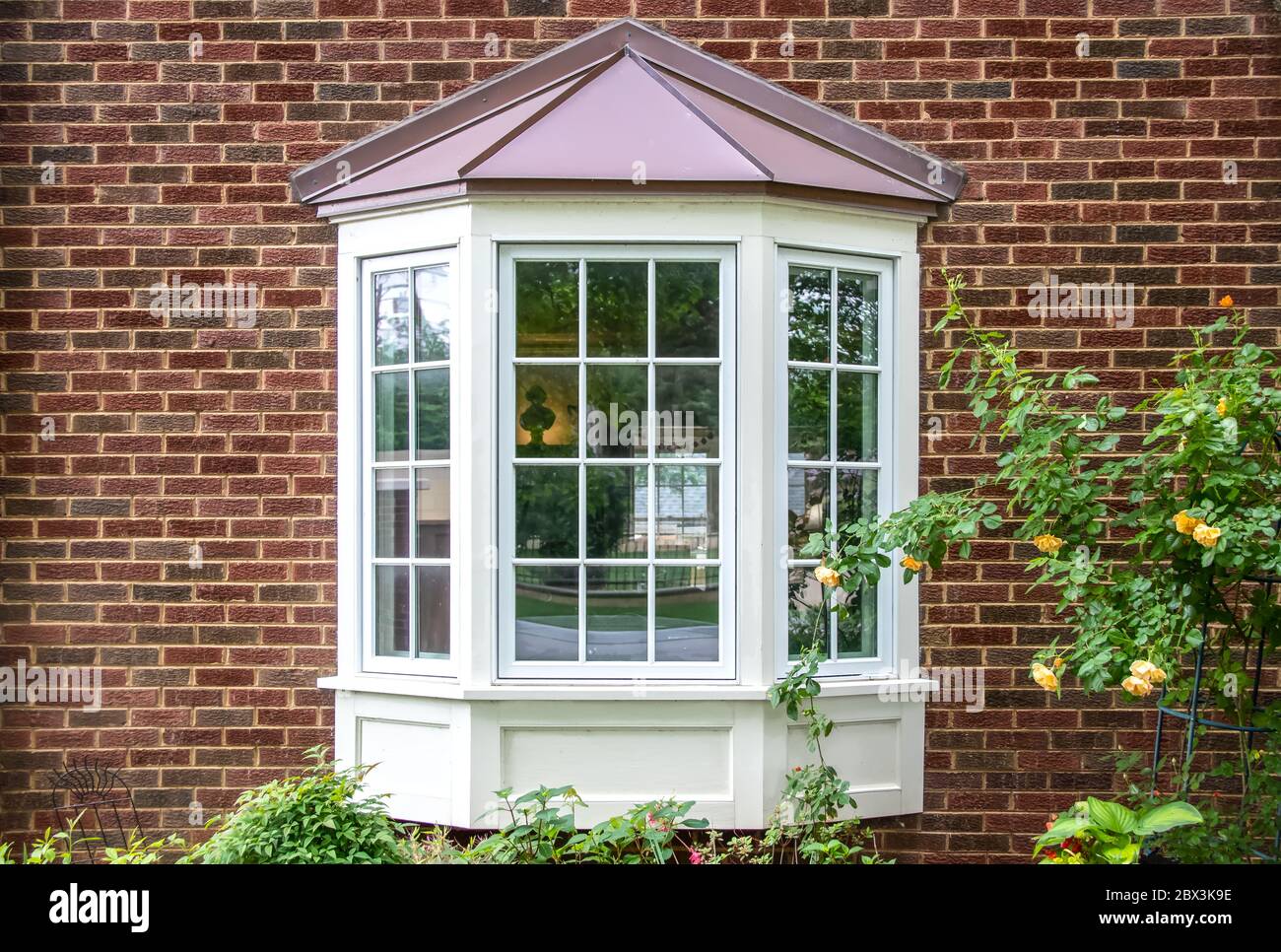 Bay window with copper roof on traditional brick home with flowers ...