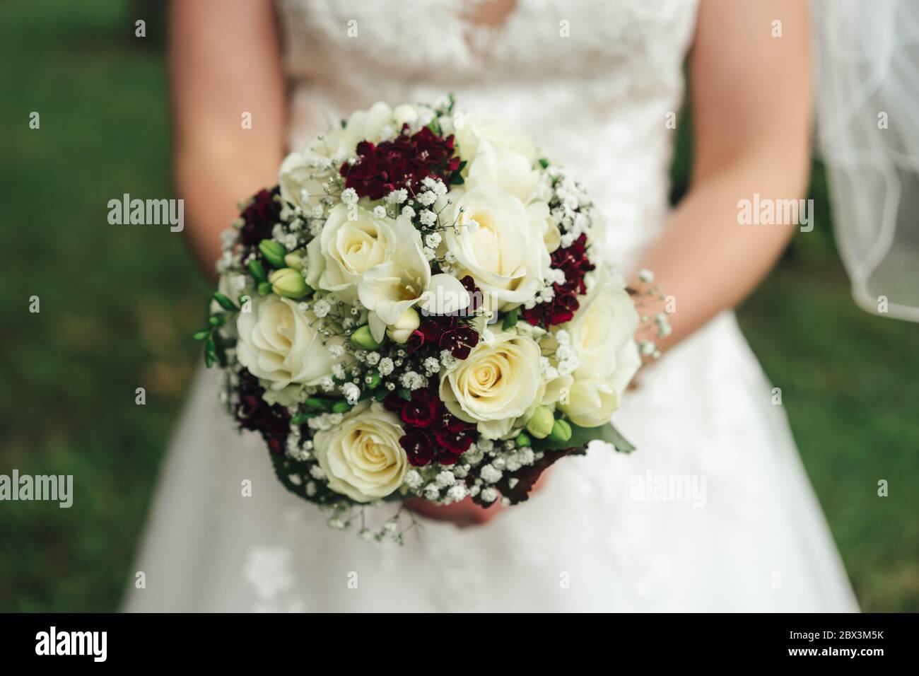 Close up wedding bouquet, white and red flowers. Bride holding flowers ...