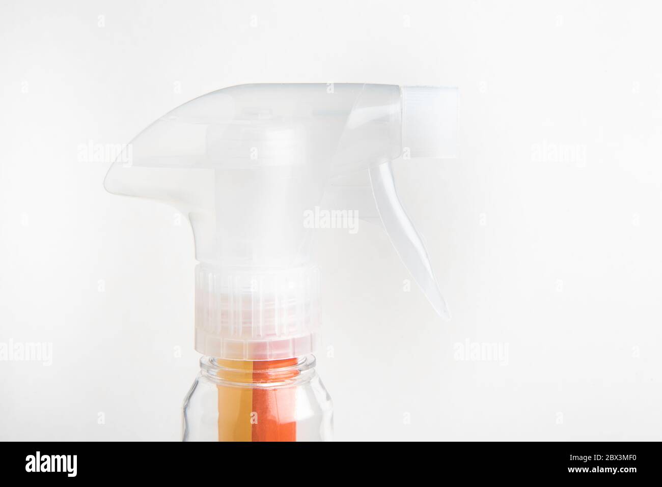 A close-up of the top portion of a transparent nozzle liquid spray ...