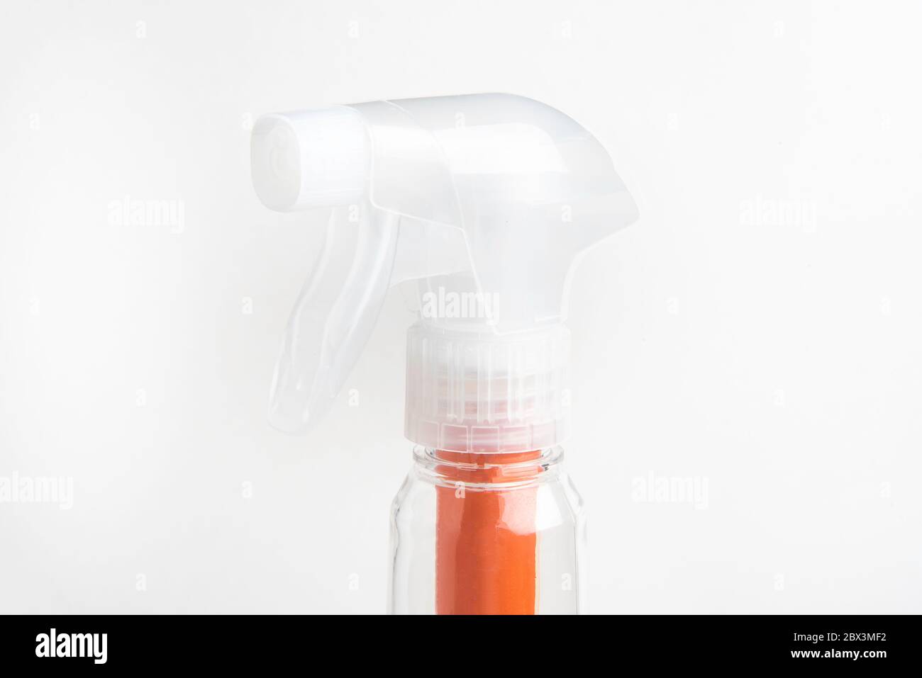 A close-up of the top portion of a transparent nozzle liquid spray ...