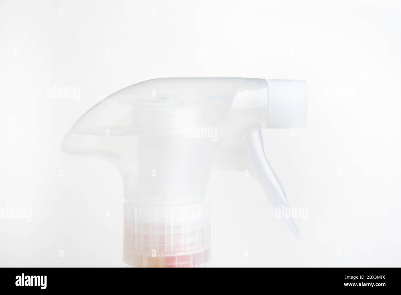 A close-up of the top portion of a transparent nozzle liquid spray ...