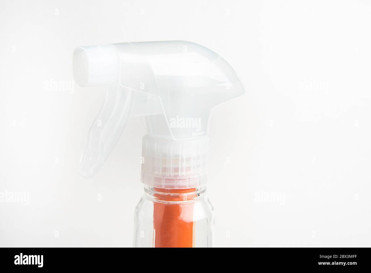 A close-up of the top portion of a transparent nozzle liquid spray ...