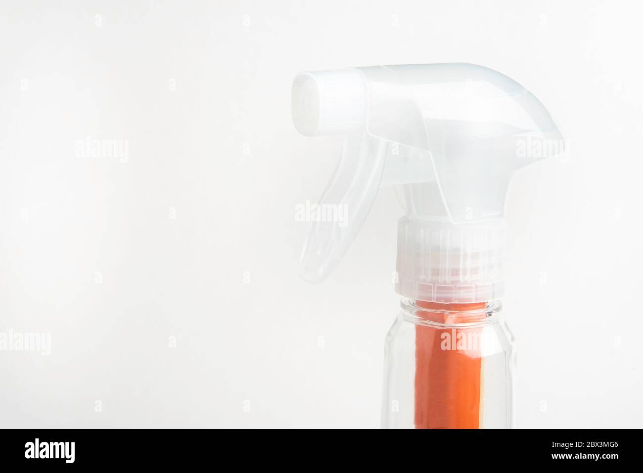 A close-up of the top portion of a transparent nozzle liquid spray ...