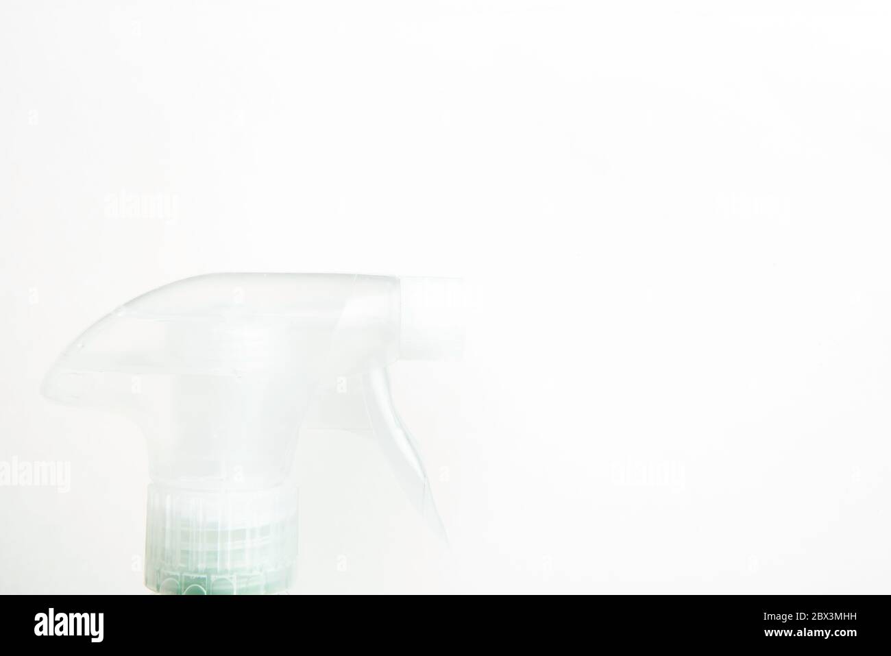 A close-up of the top portion of a transparent nozzle liquid spray ...