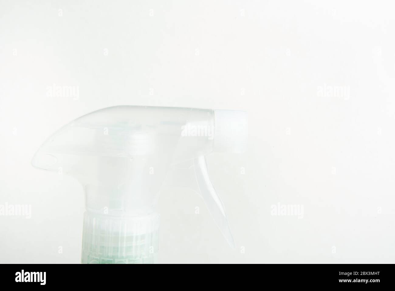 A close-up of the top portion of a transparent nozzle liquid spray ...