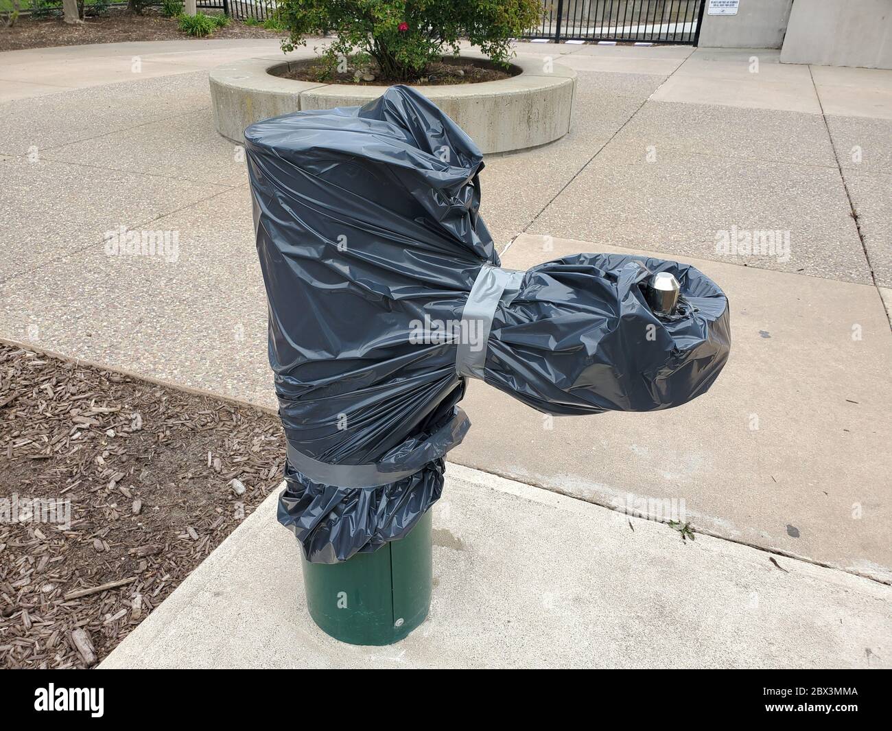A water fountain has been wrapped in plastic to prevent its use during ...