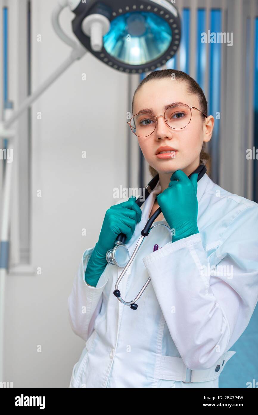 Doctor in a white coat holding a phonendoscope on the background of a ...