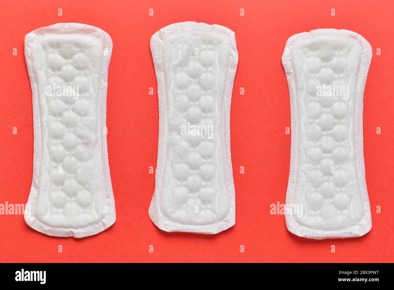 Three female pads on a red background Stock Photo - Alamy